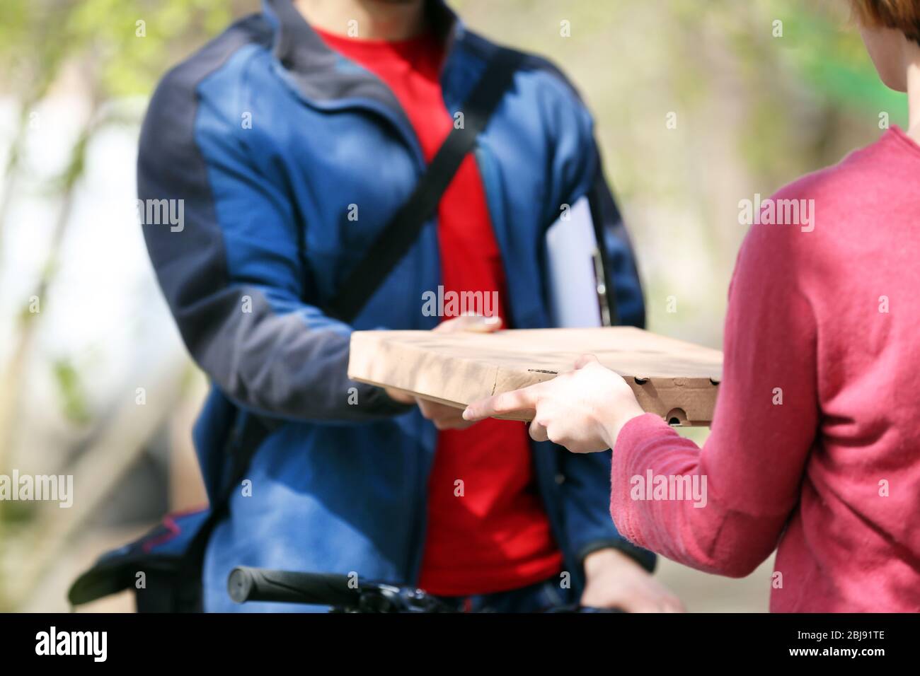 Young man delivering pizza to client Stock Photo - Alamy