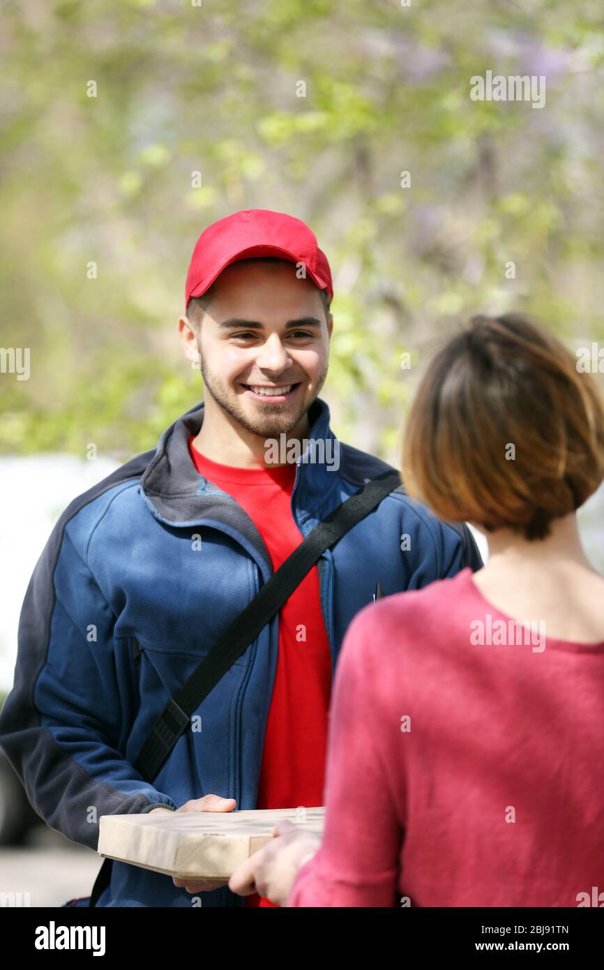 Young man delivering pizza to client Stock Photo - Alamy