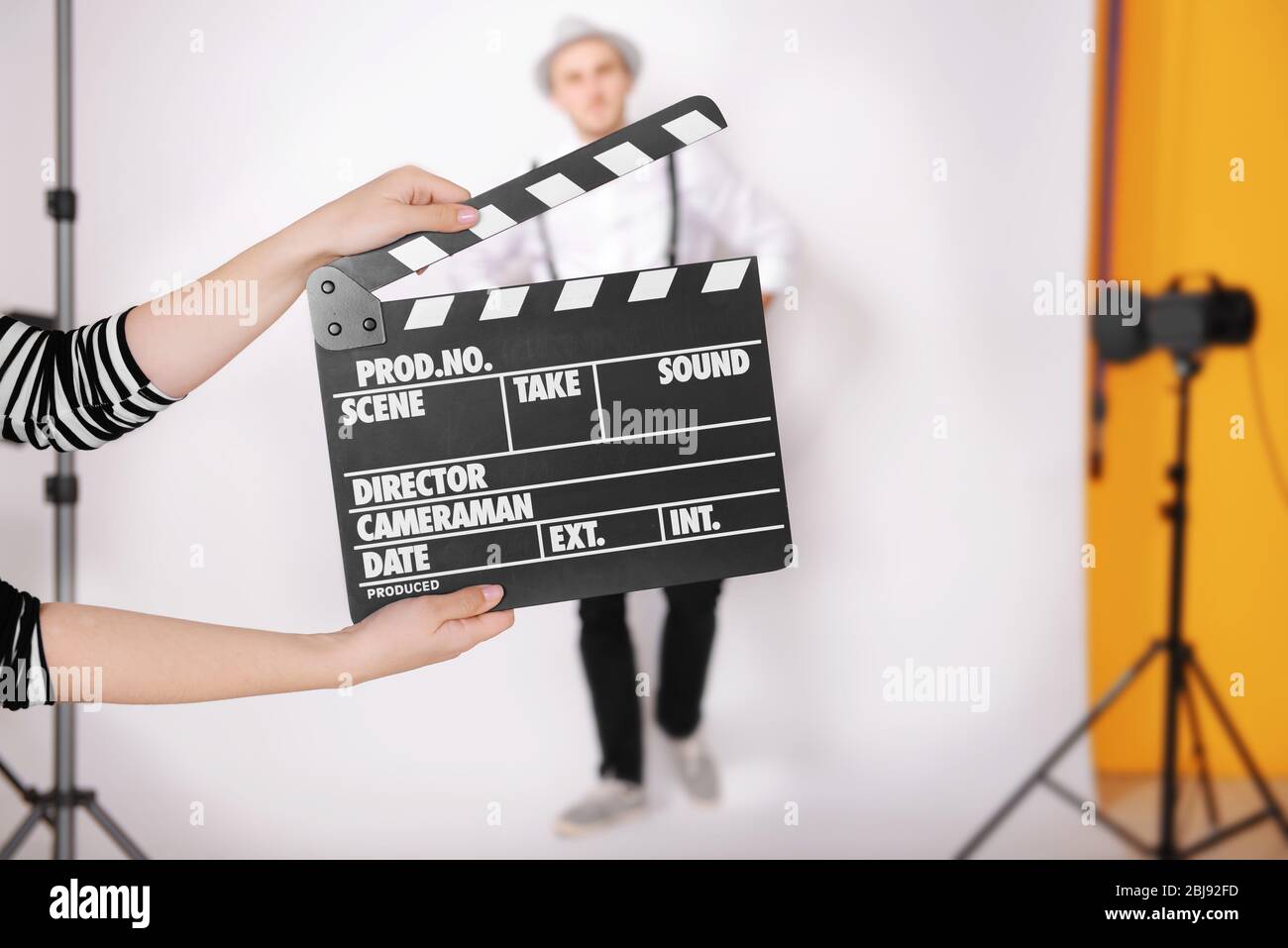Movie clapper and young man on background in photo studio Stock Photo ...