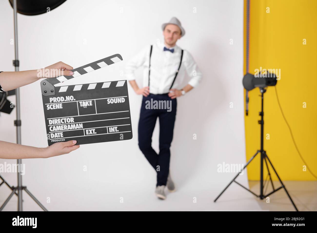 Movie clapper and young man on background in photo studio Stock Photo ...