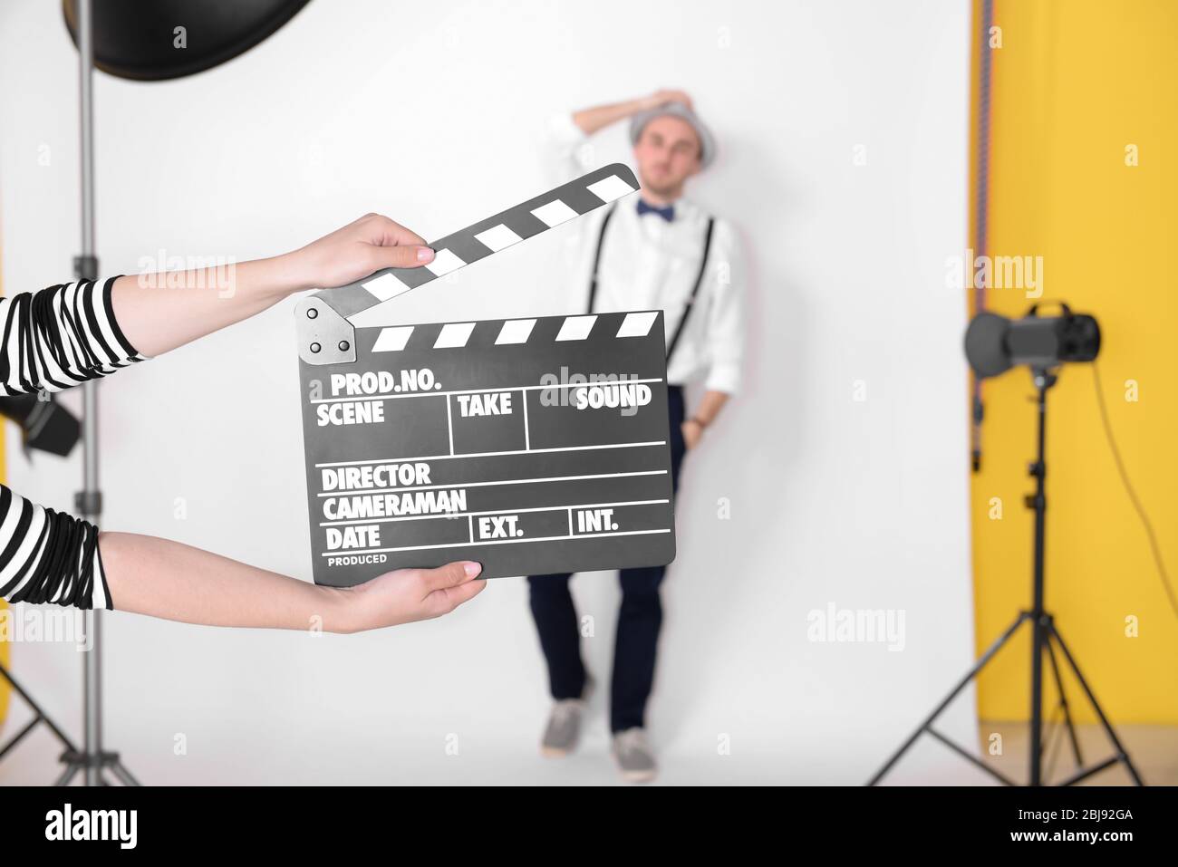Movie clapper and young man on background in photo studio Stock Photo ...
