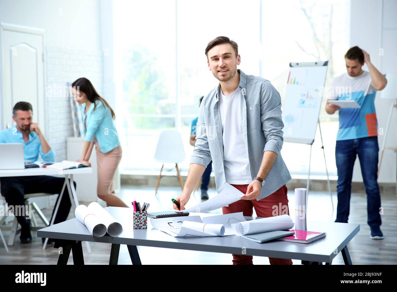 Young engineer working with blueprints at table indoors Stock Photo - Alamy
