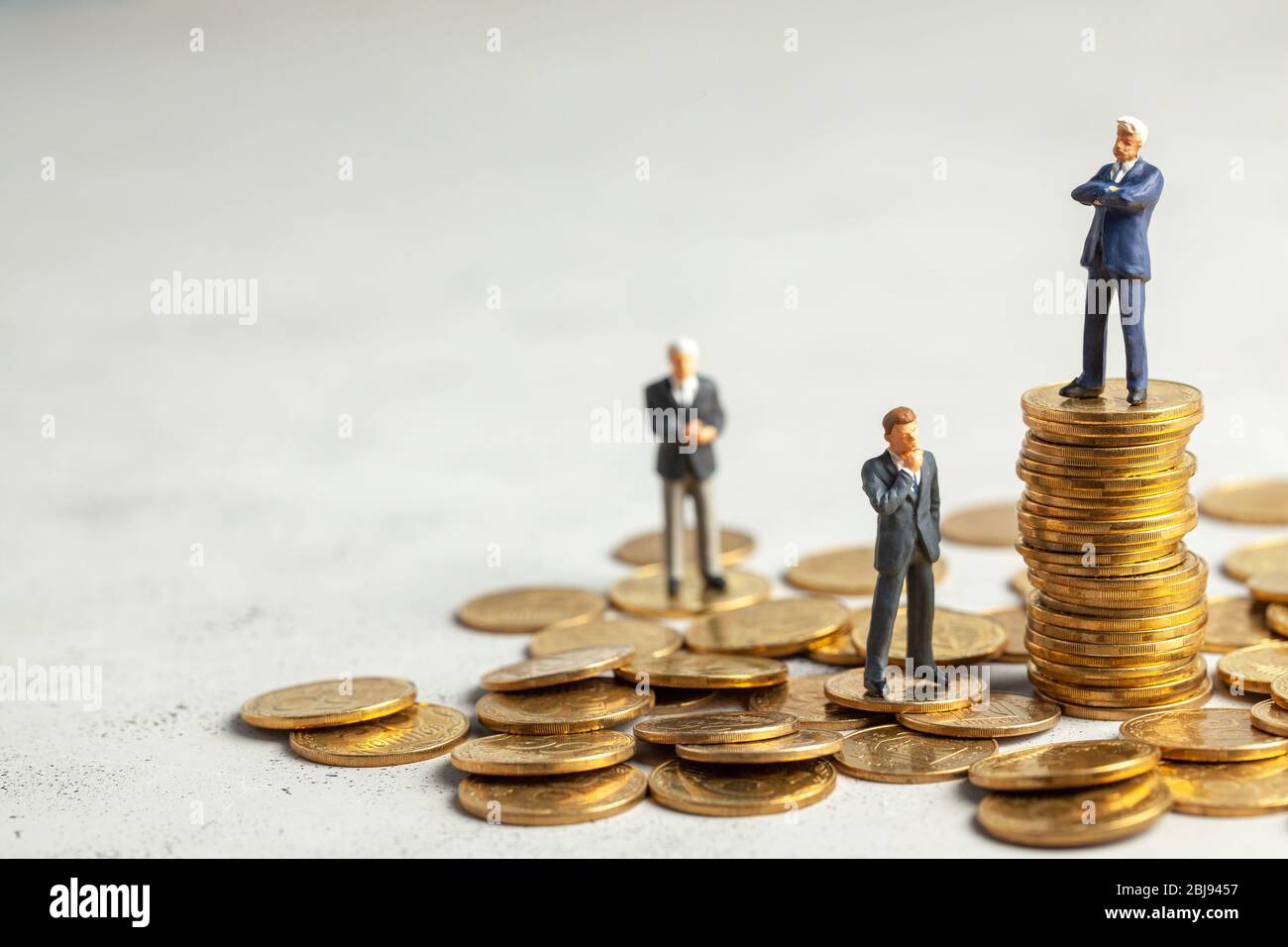 Successful businessman with big profits on stack of gold coins and less ...