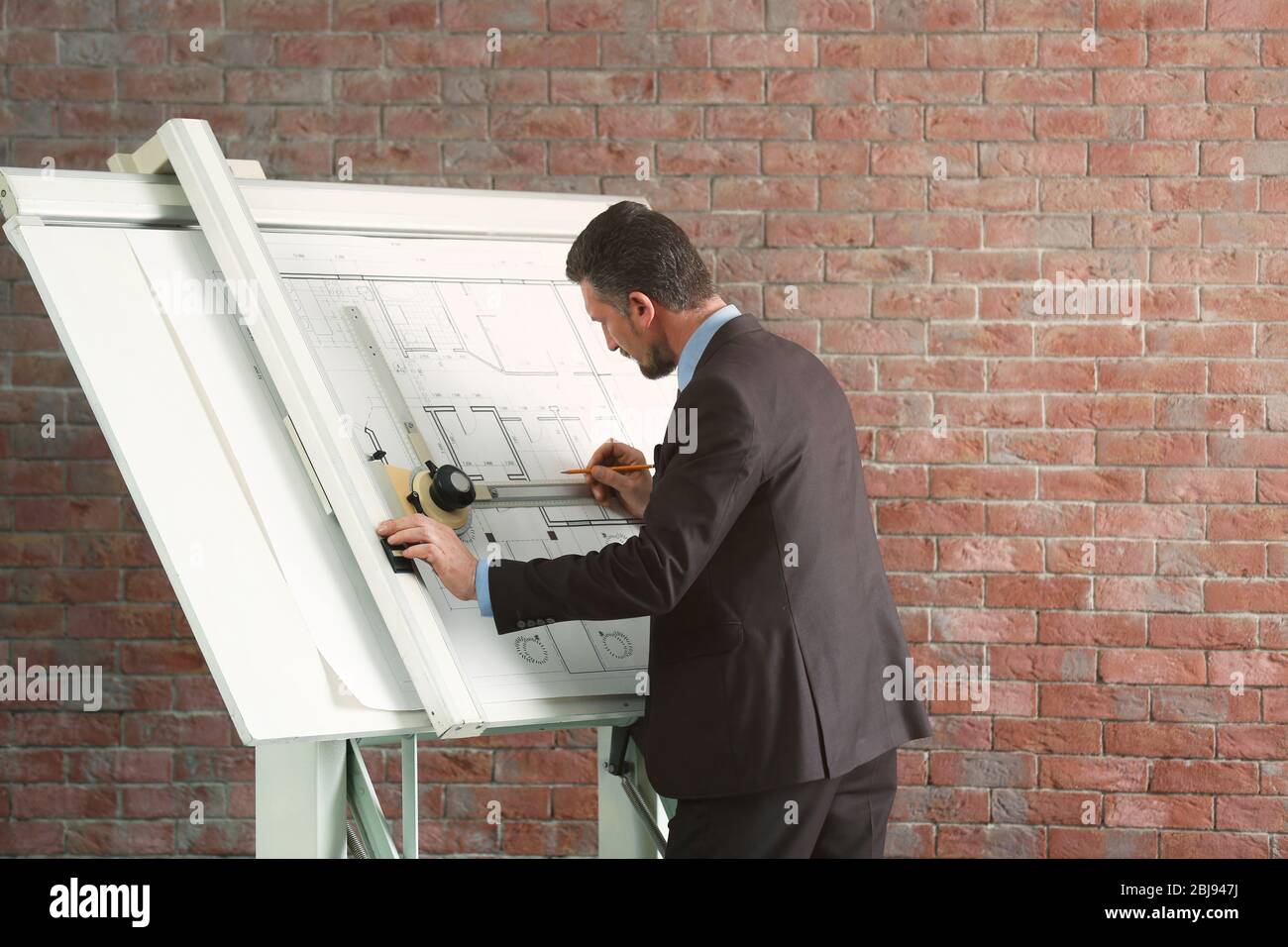 Engineer working with blueprint on panel board indoors Stock Photo - Alamy