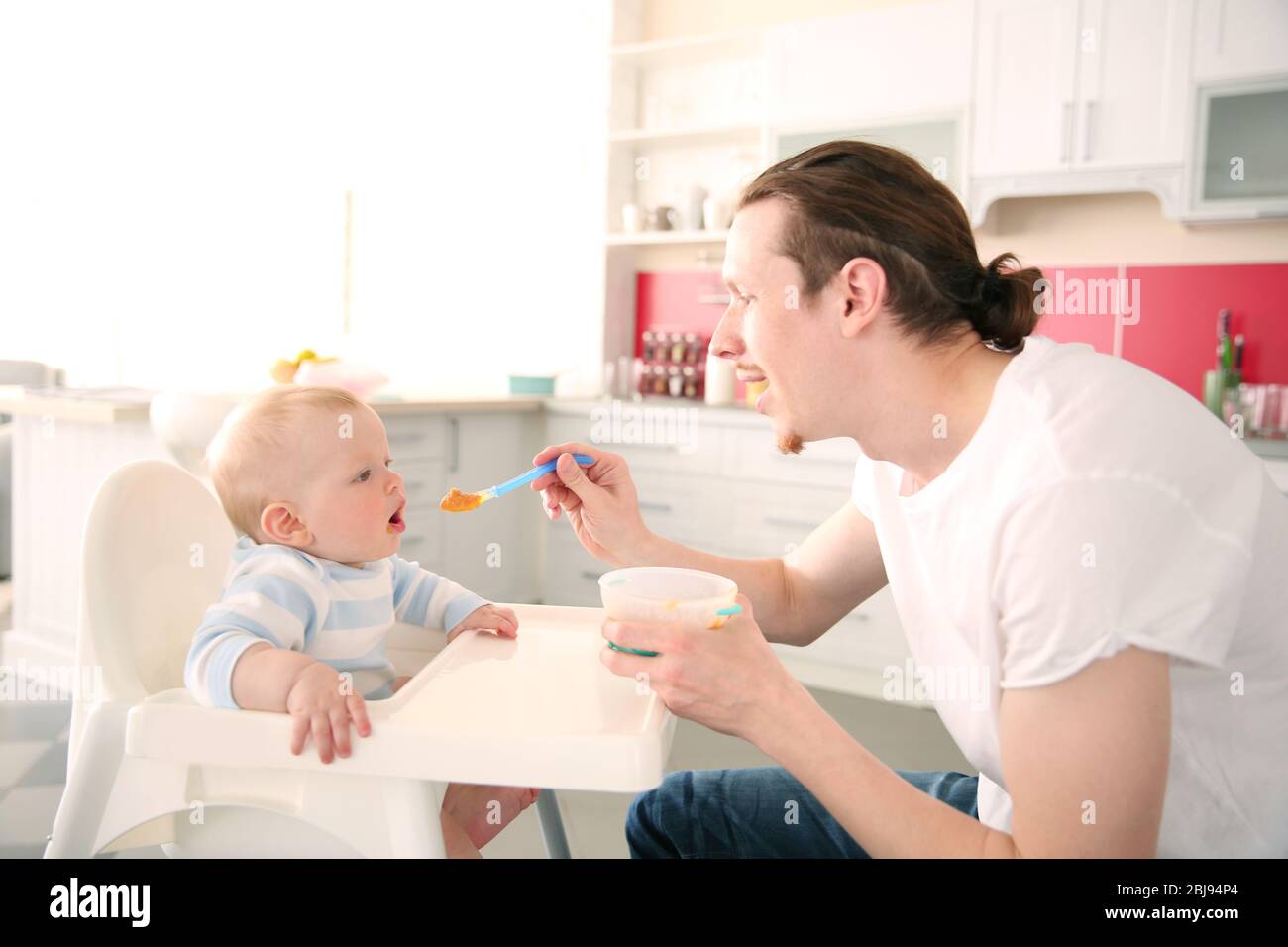 Father feeding his baby son Stock Photo - Alamy