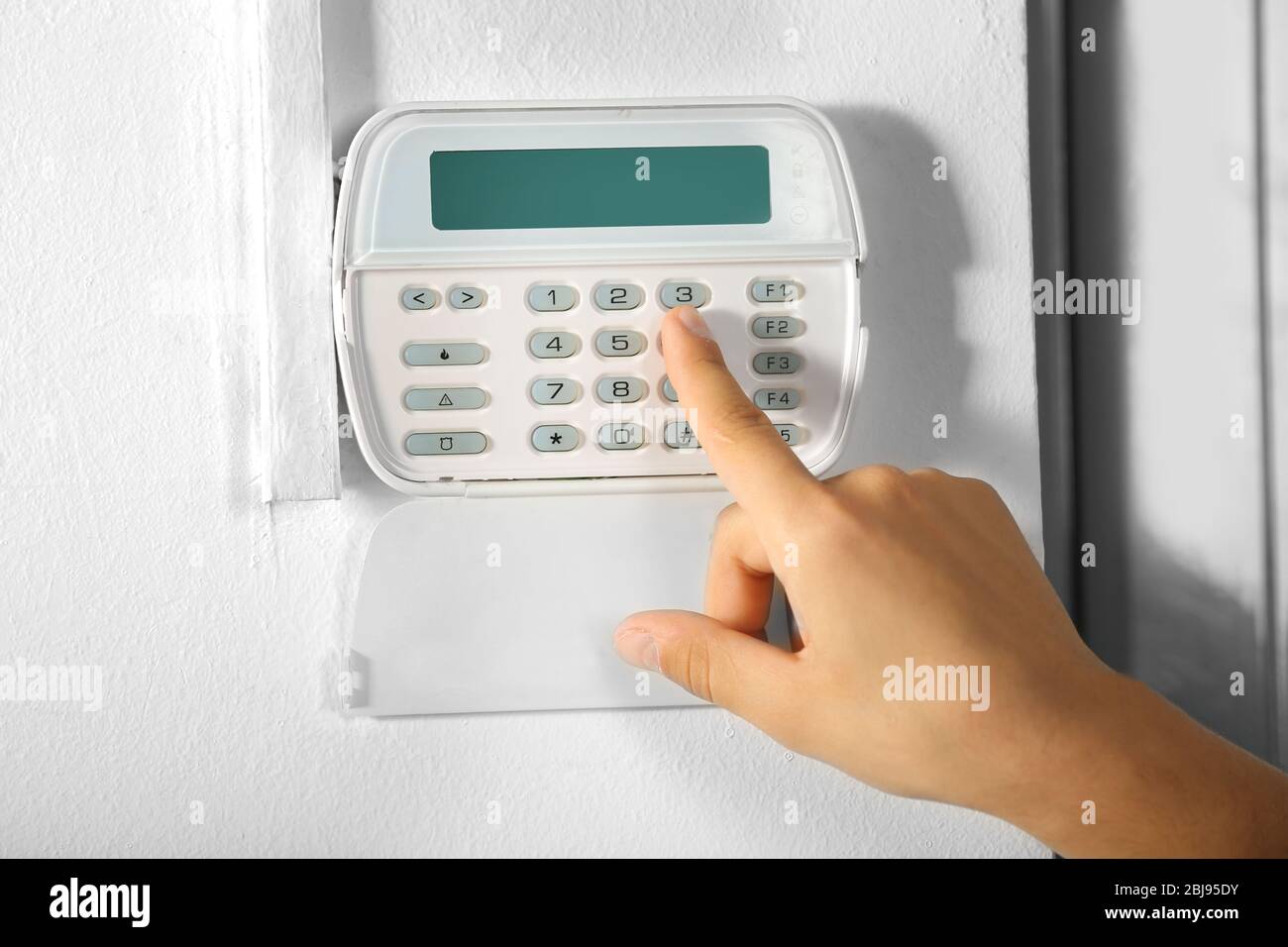 Male hand pressing the code on a house alarm Stock Photo - Alamy