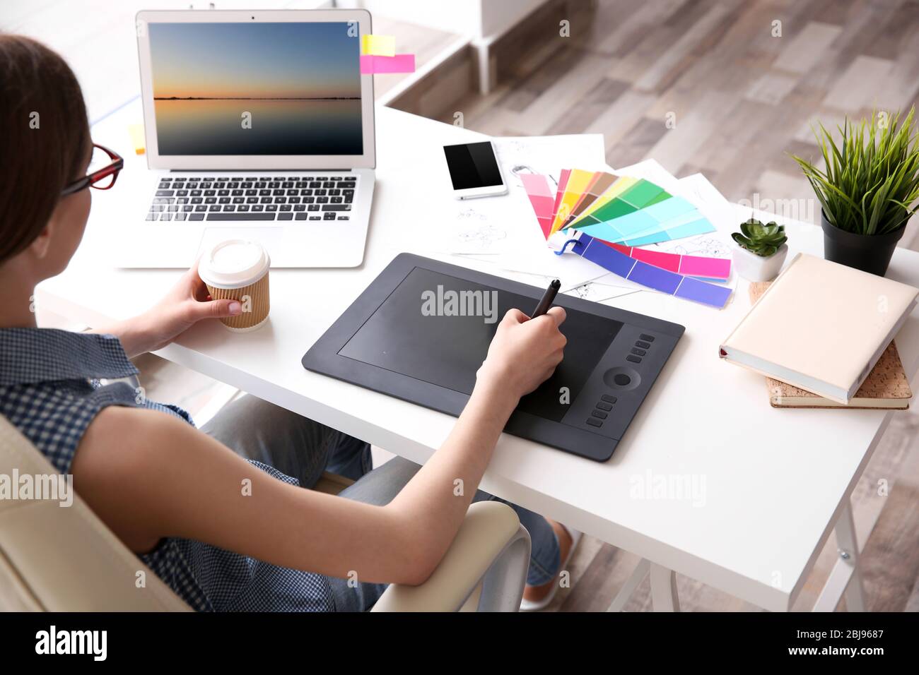 Woman using graphic tablet at office Stock Photo - Alamy