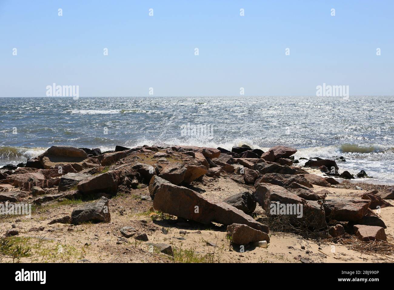 Rock seacoast with blue sea on background Stock Photo - Alamy