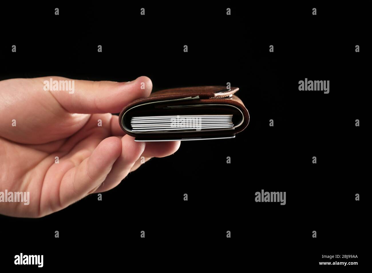 Man holding wallet on black background Stock Photo - Alamy