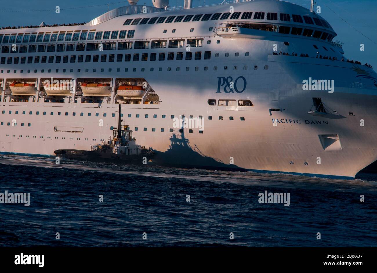 Tug boat Sydney harbour with Pacific Dawn Stock Photo - Alamy