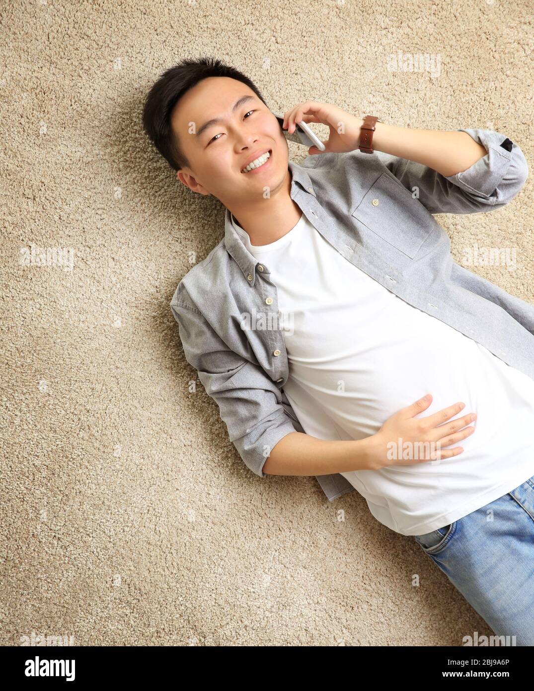 Handsome man lying on floor Stock Photo - Alamy