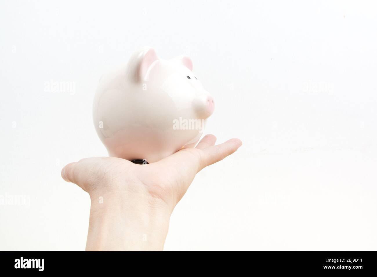 Pink piggy bank hand hi-res stock photography and images - Alamy