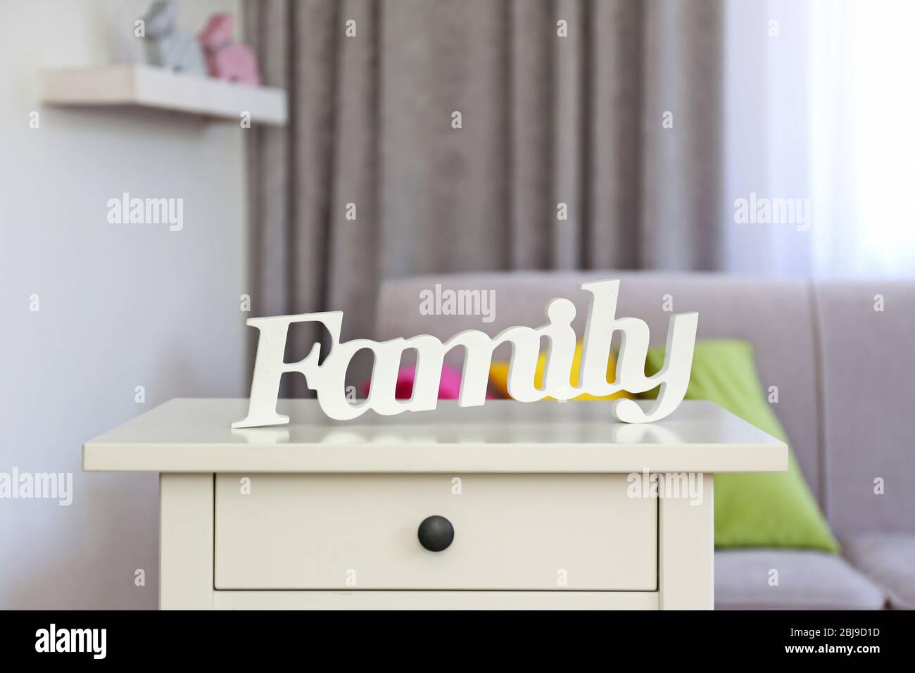 Wooden text Family in modern interior Stock Photo - Alamy