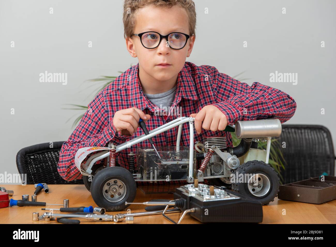 little boy repairing a model radio-controlled car Stock Photo - Alamy