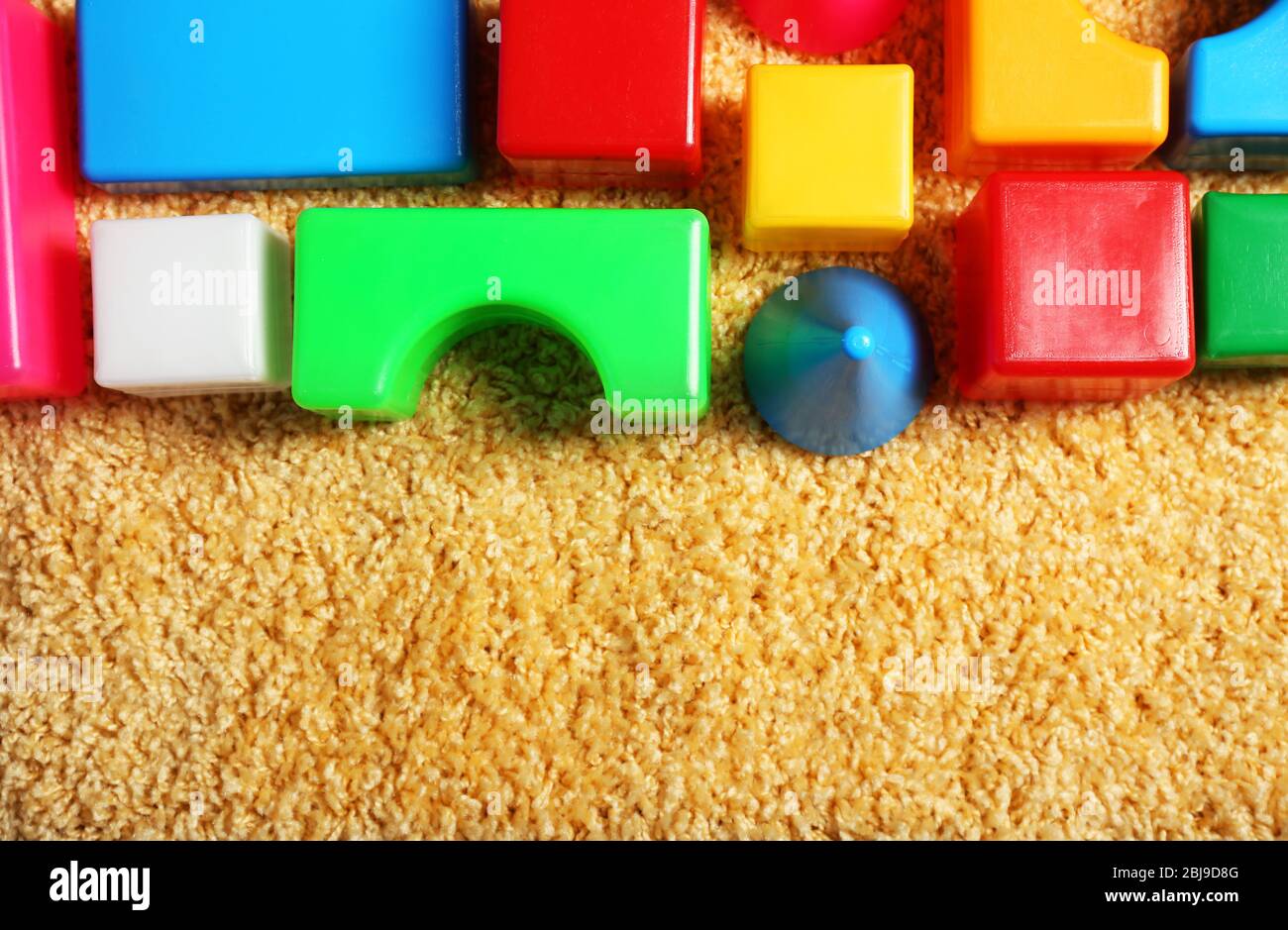 Colorful plastic kids toys on carpet Stock Photo - Alamy