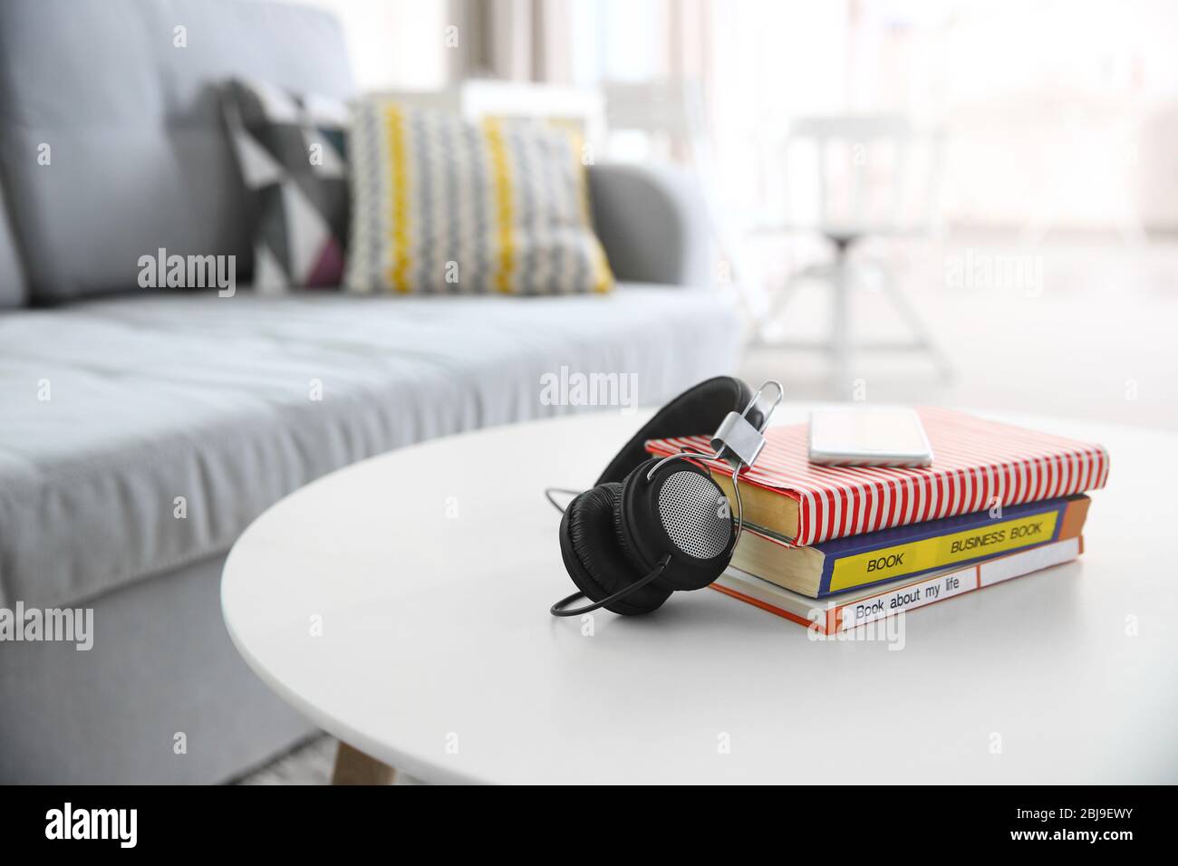 New headphones on the table in living room Stock Photo - Alamy