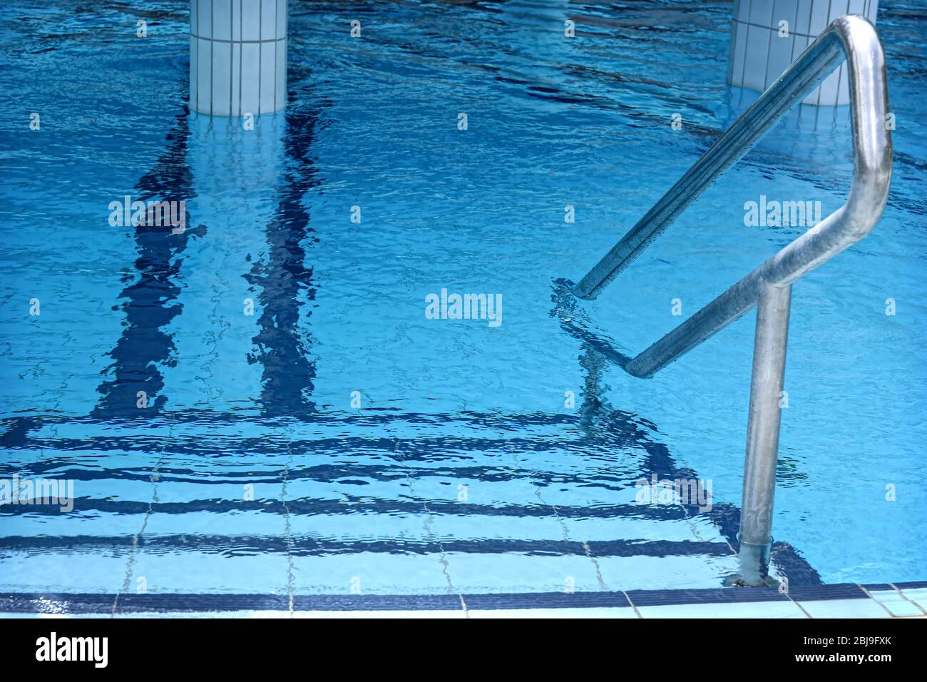 Grab bars ladder in swimming pool Stock Photo - Alamy