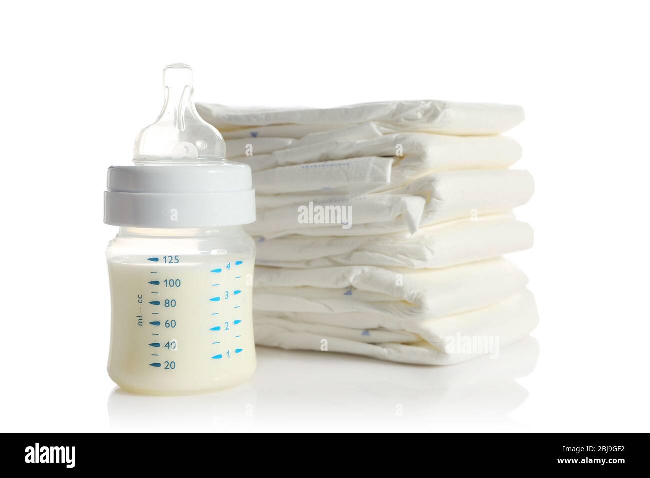 Baby bottle with milk and pile of diapers isolated on white Stock Photo ...
