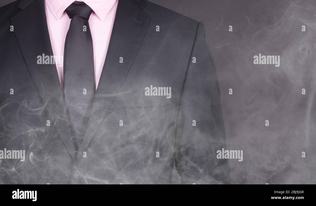 Man in a black suit and black tie, standing in smoke, close-up Stock ...