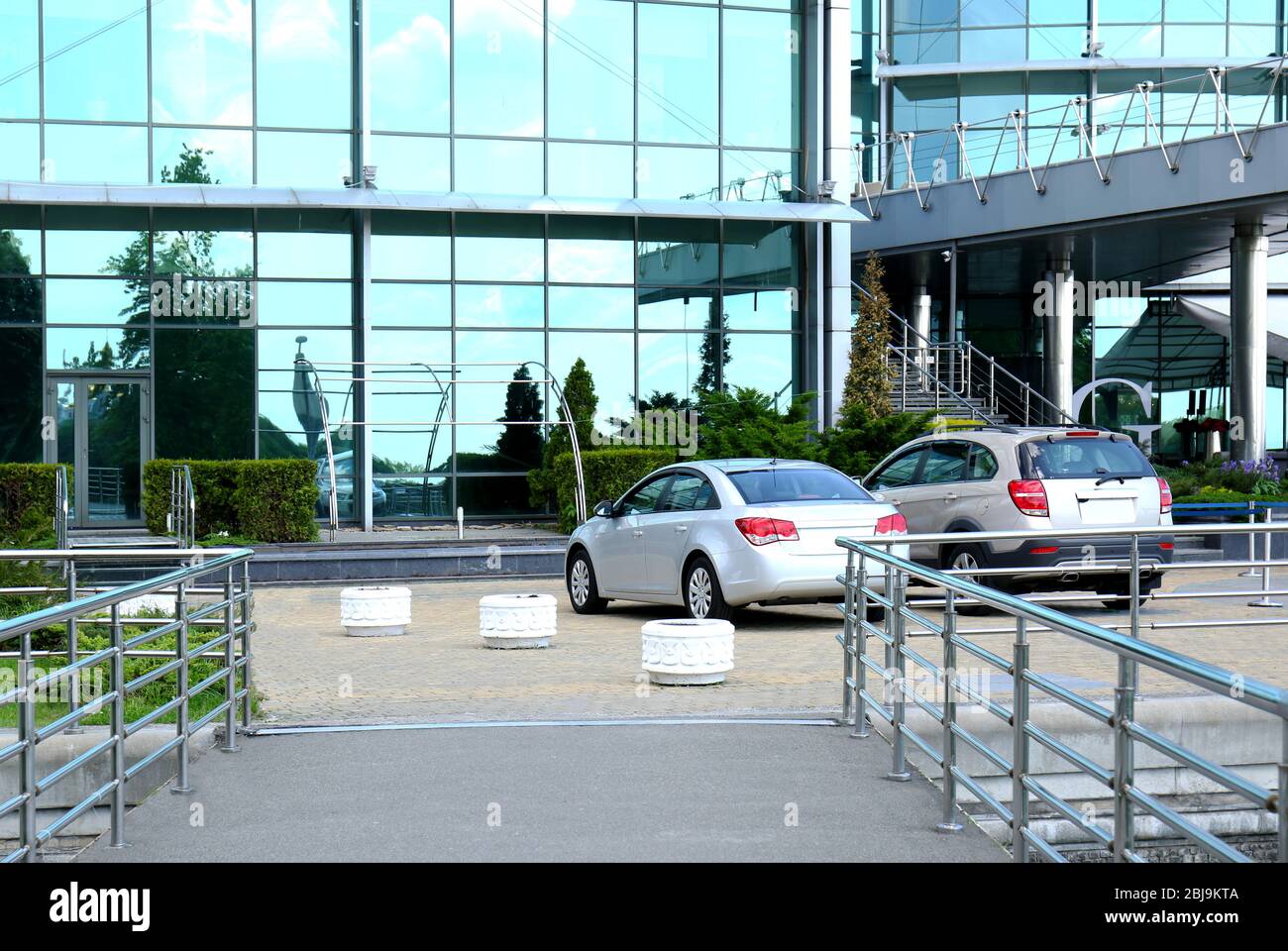 Parked cars near modern office building Stock Photo - Alamy