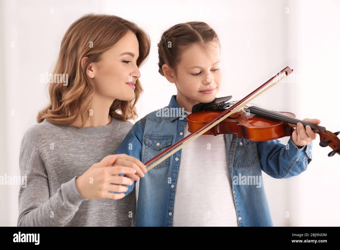 Small girl learning play violin with teacher Stock Photo - Alamy