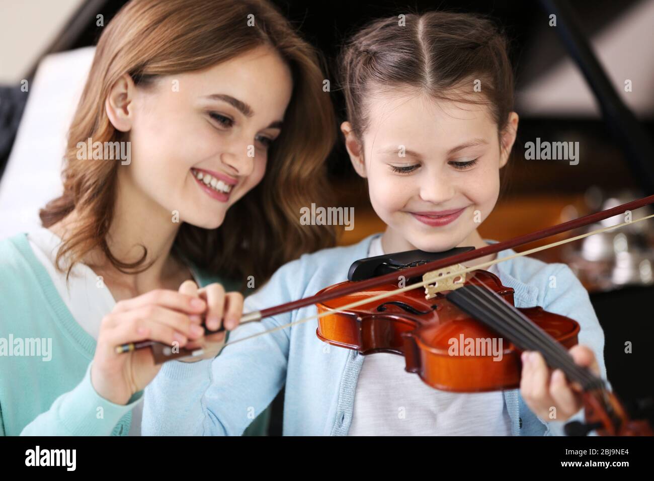 Small girl learning play violin with teacher Stock Photo - Alamy