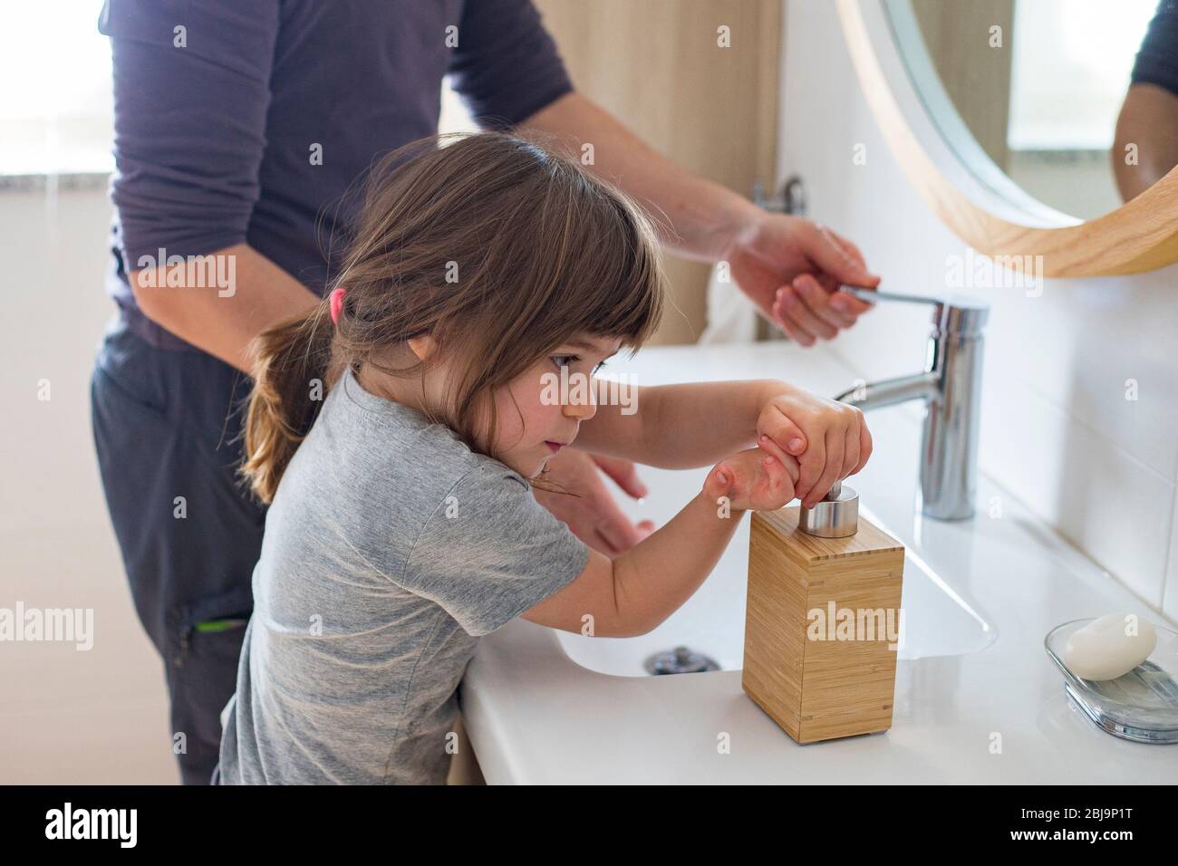 Caucasian father teaching little child girl how to wash hands in ...