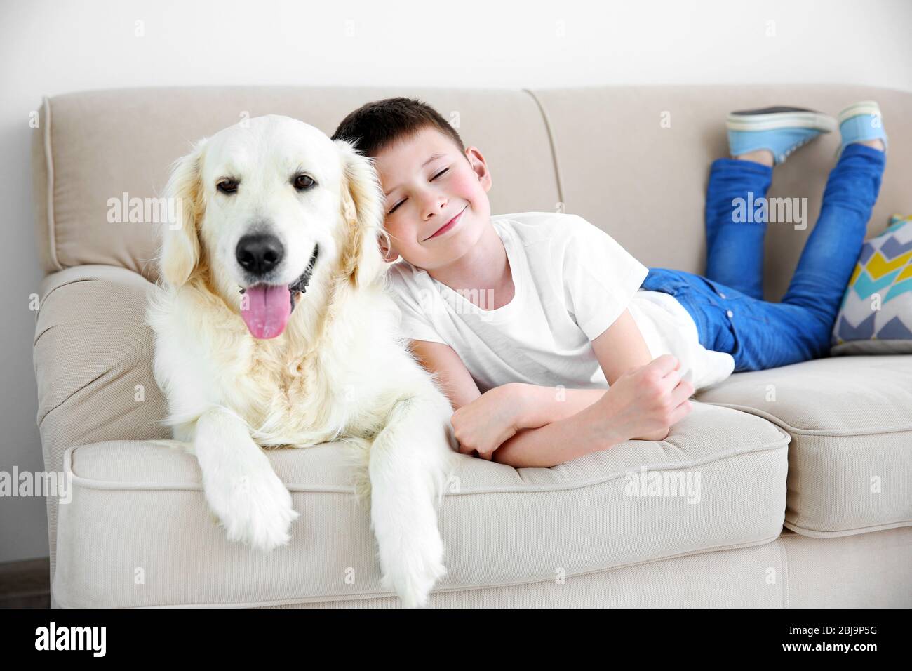 Small boy and cute dog on couch Stock Photo - Alamy