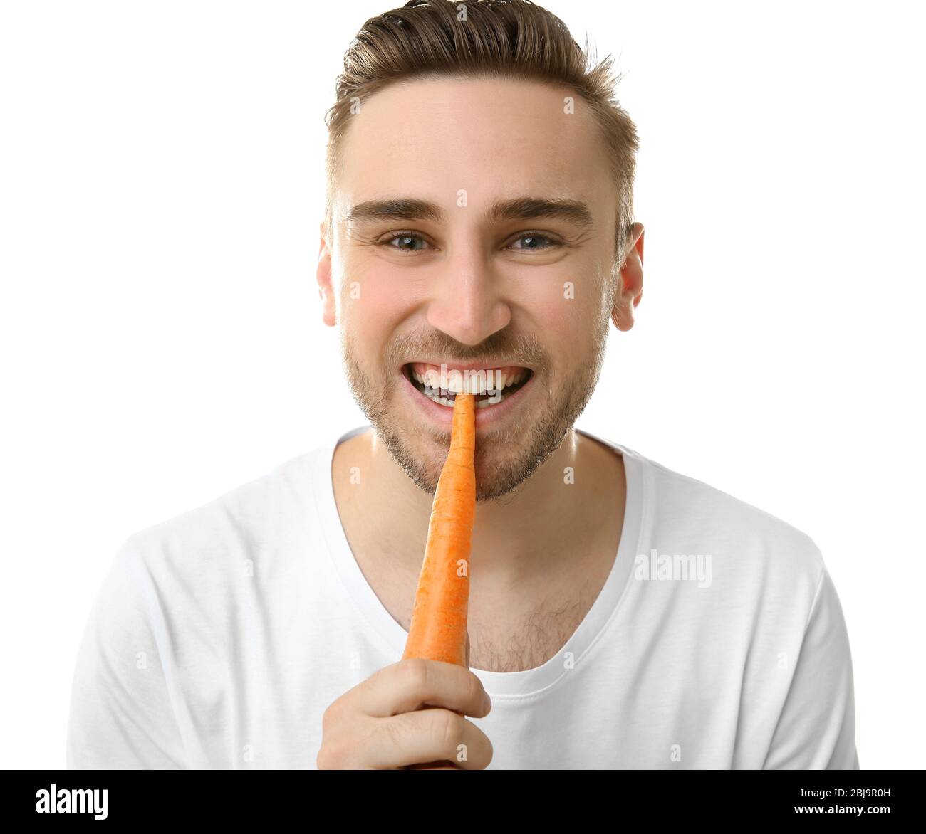 Handsome man eating carrot, isolated on white Stock Photo - Alamy