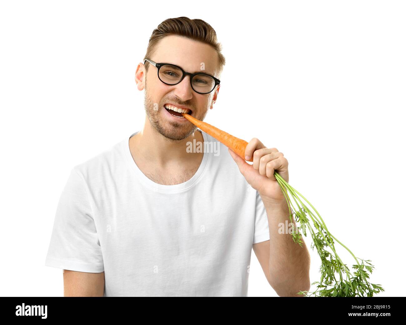 Handsome man eating carrot, isolated on white Stock Photo - Alamy