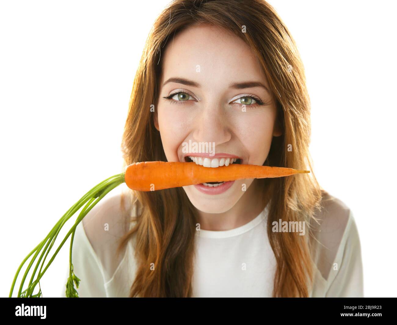 Beautiful girl eating carrot, isolated on white Stock Photo - Alamy
