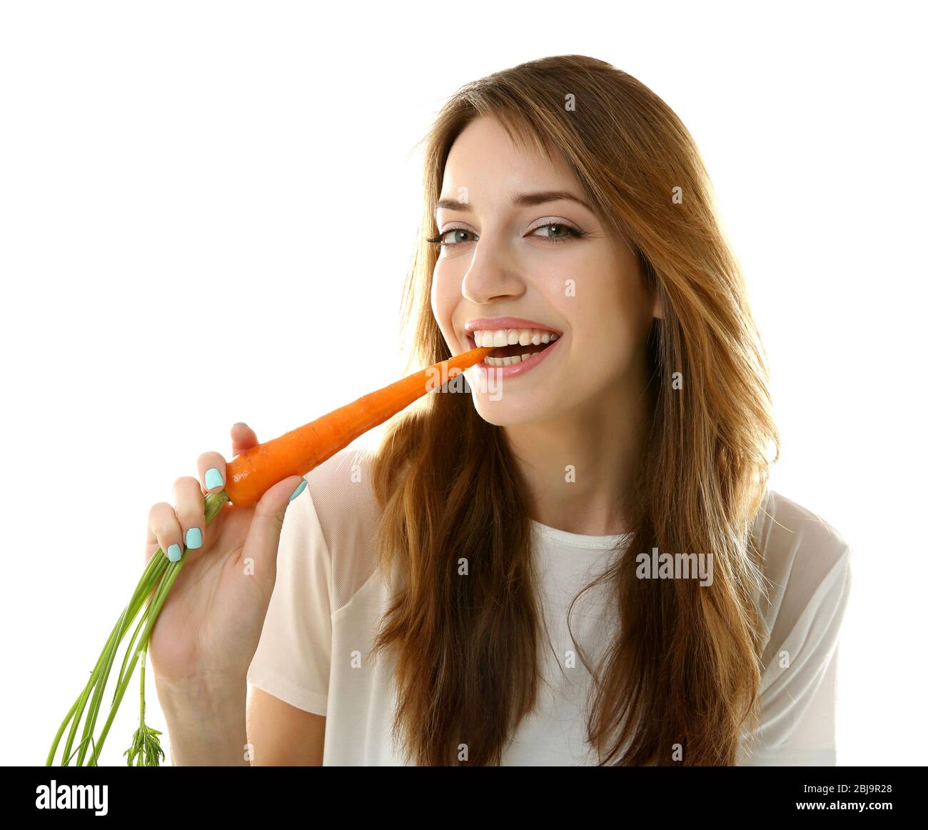 Beautiful girl eating carrot, isolated on white Stock Photo - Alamy