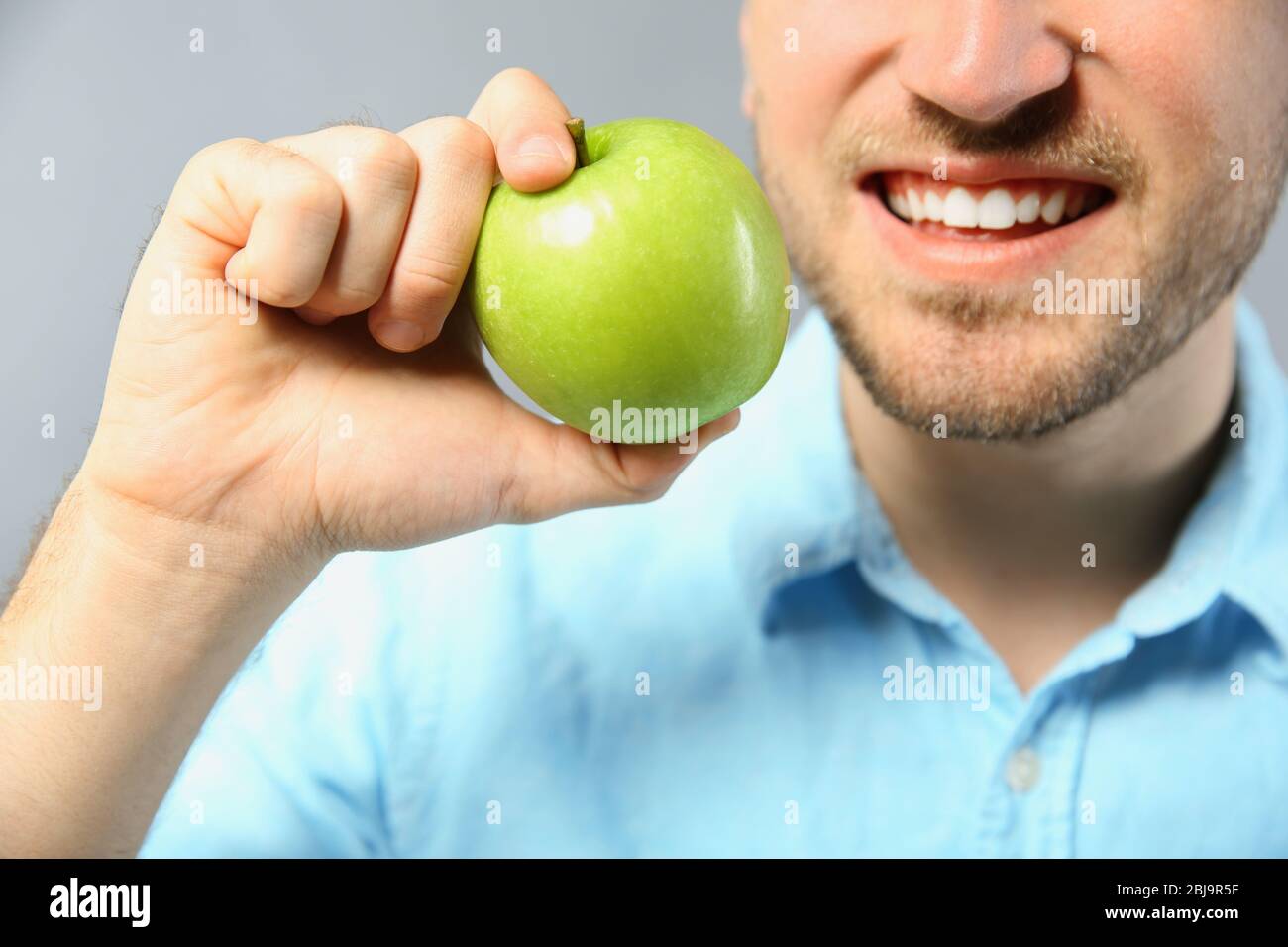 Handsome man eat apple, closeup Stock Photo - Alamy
