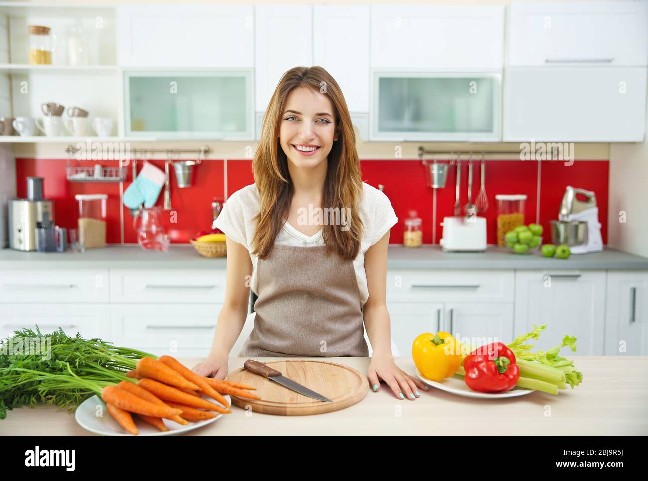Beautiful girl cutting vegetables in kitchen Stock Photo - Alamy