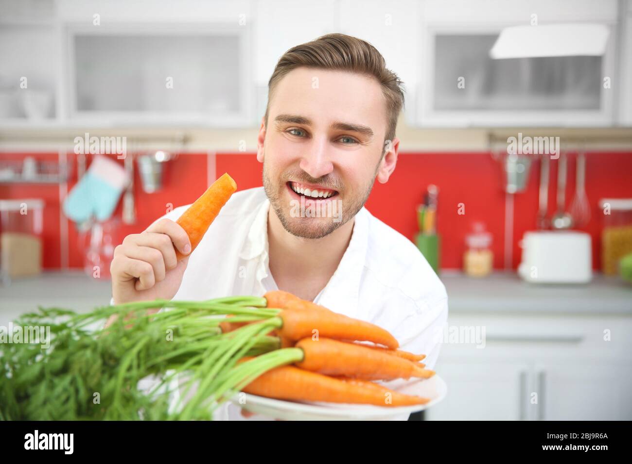 Vegan man holding carrot kitchen hi-res stock photography and images ...