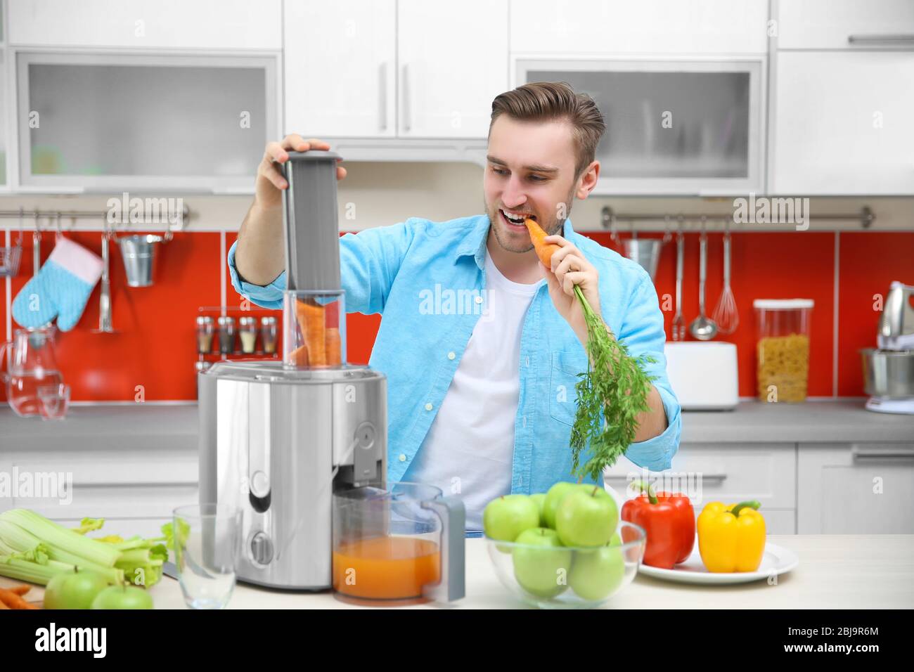 Handsome man making juice in kitchen Stock Photo - Alamy