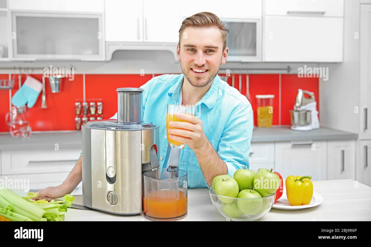 Handsome man with juice in kitchen Stock Photo - Alamy