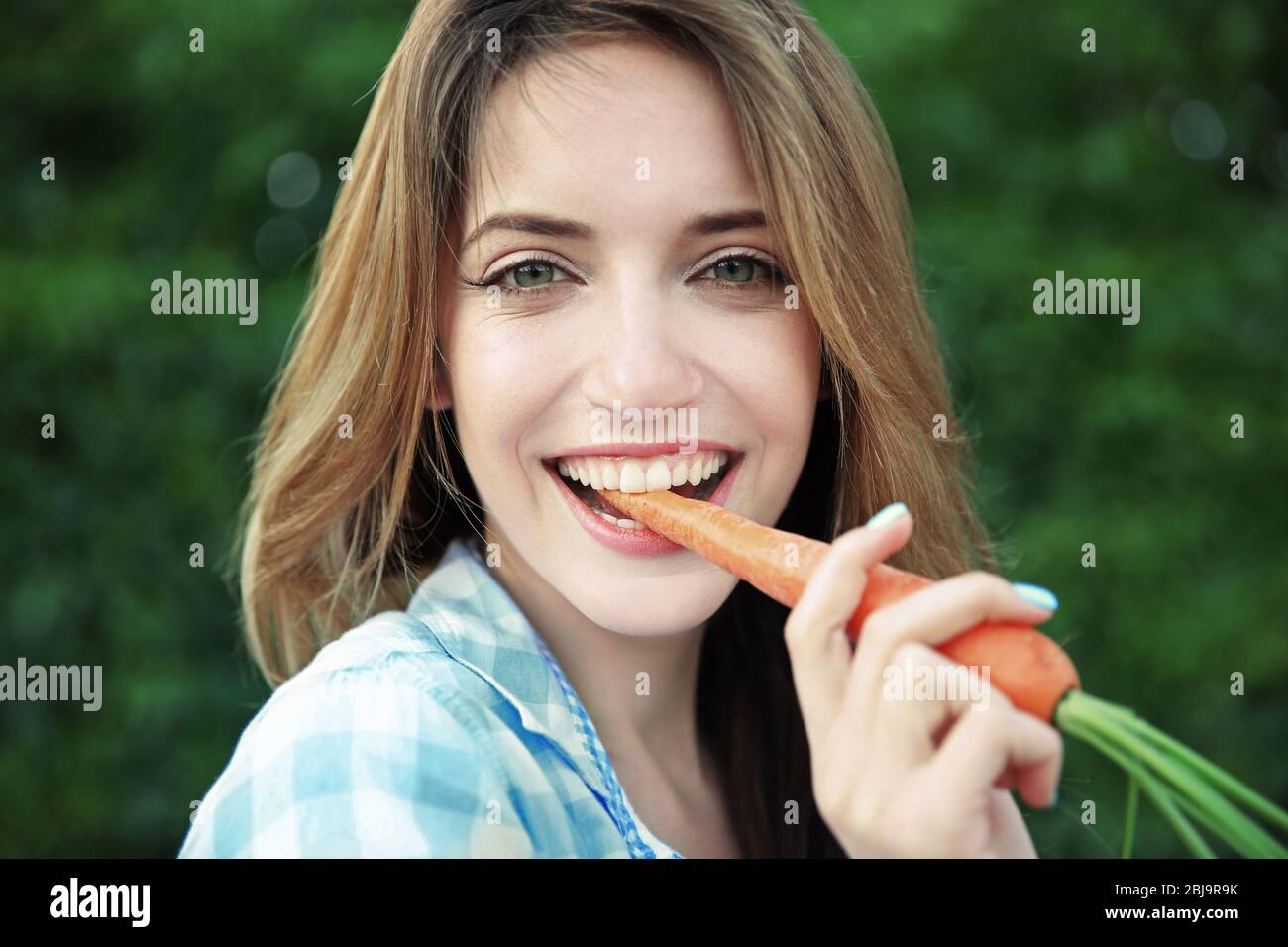 Beautiful girl eating carrot, closeup Stock Photo - Alamy