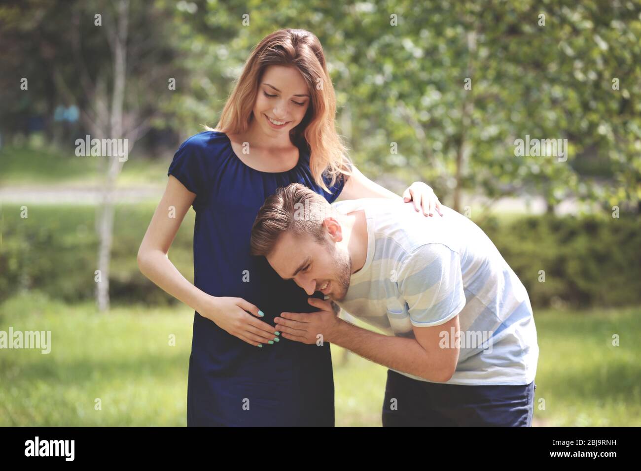 Happy family expecting baby on green nature background Stock Photo - Alamy