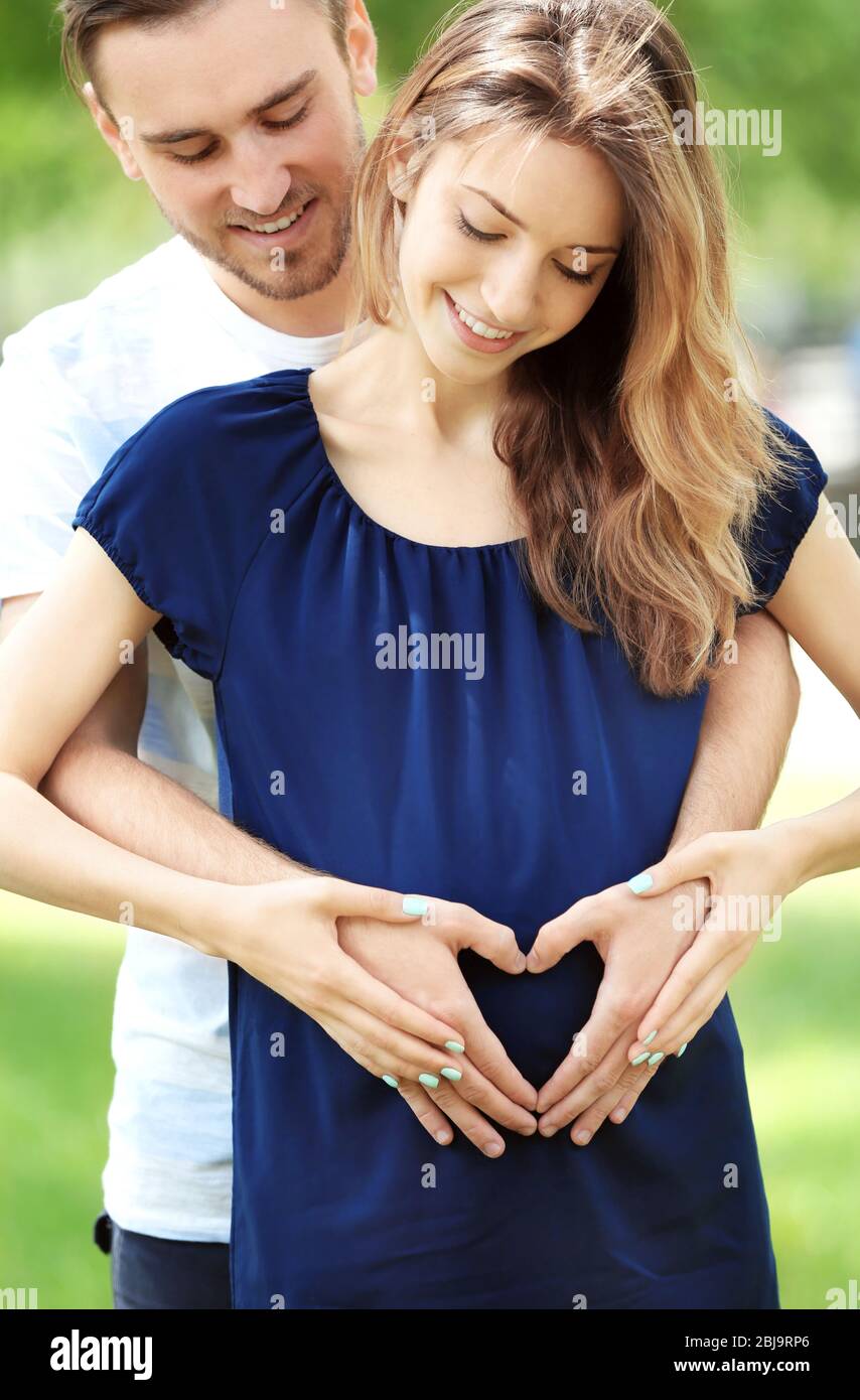 Happy family expecting baby on green nature background Stock Photo - Alamy