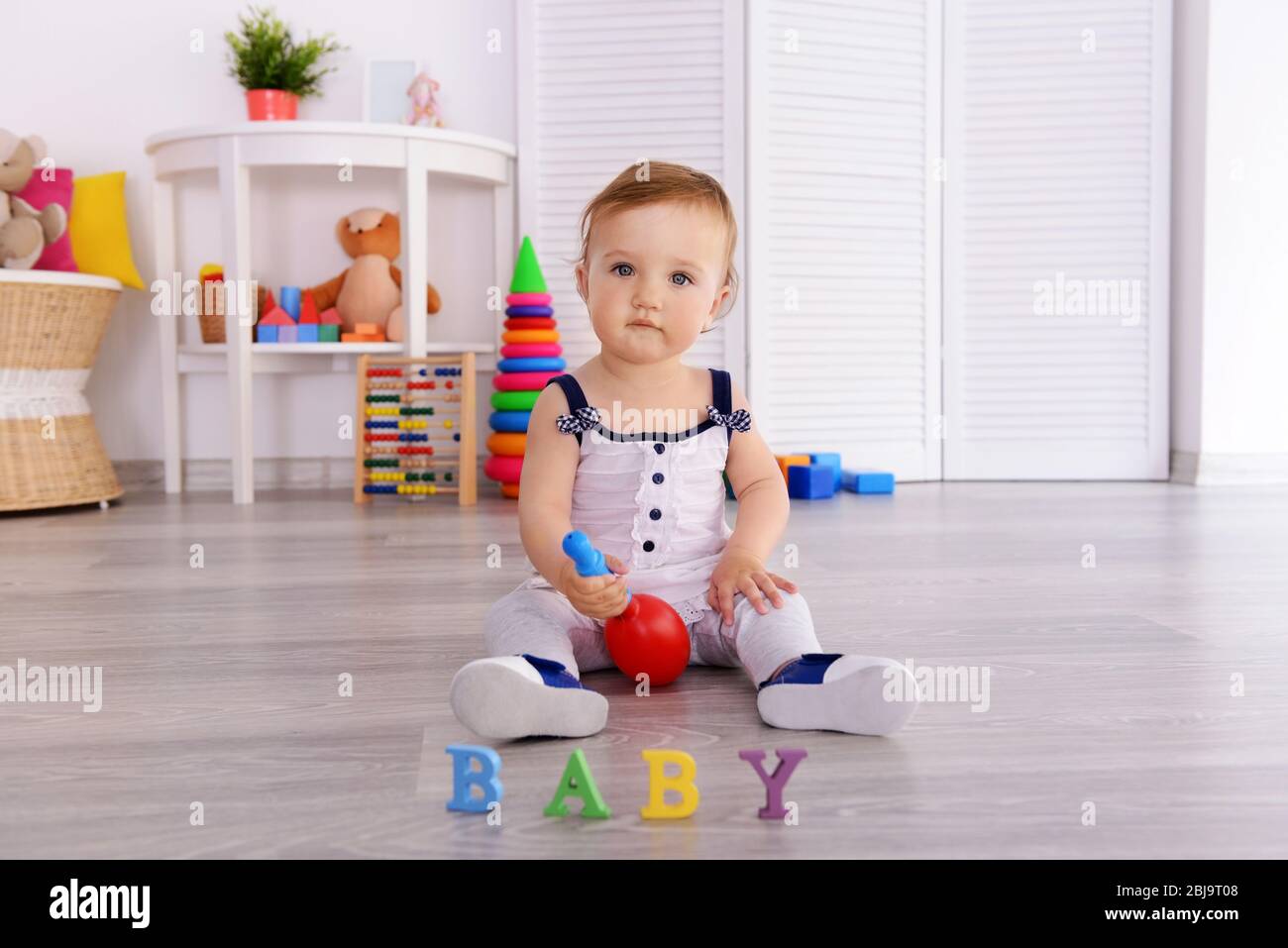 Baby playing with toys in room Stock Photo - Alamy