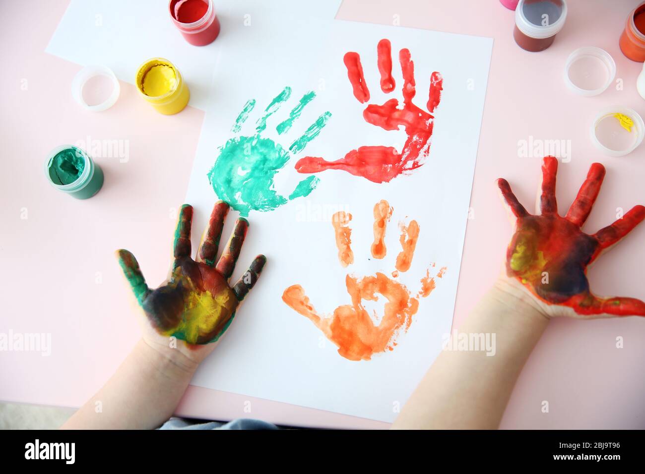 Child making hand prints on paper Stock Photo - Alamy