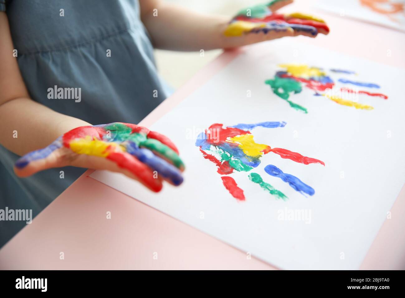 Child making hand prints on paper Stock Photo - Alamy