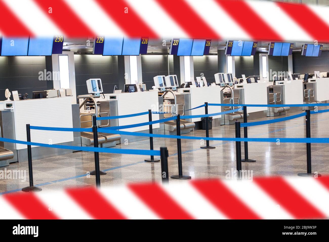Empty closed airport terminal check-in hall with warning tape. Covid-19 ...