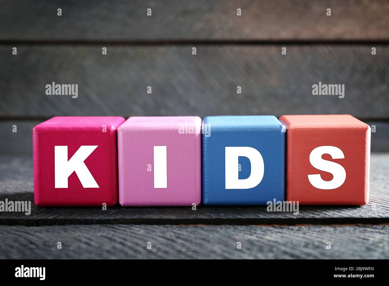 Colorful cubes with word KIDS on wooden background Stock Photo - Alamy