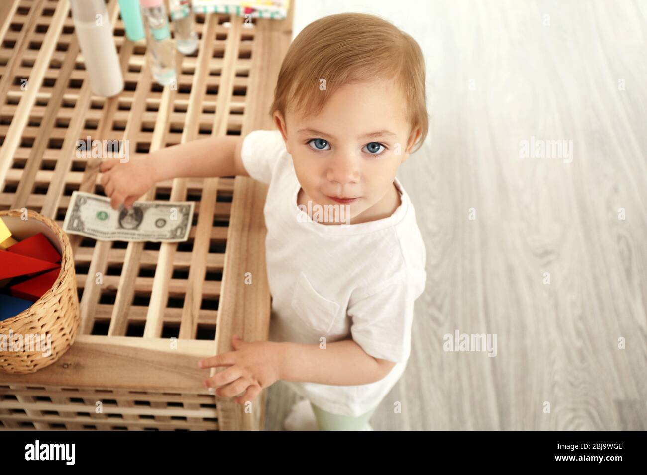 Cute baby girl with dollar banknote at home Stock Photo - Alamy