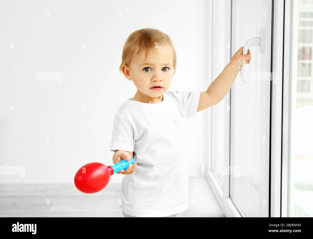 Little kid standing on a windowsill Stock Photo - Alamy