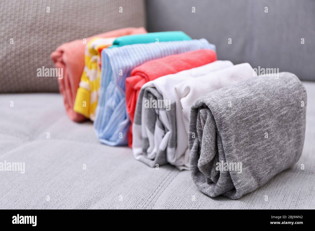 Stack of clothes on couch Stock Photo - Alamy