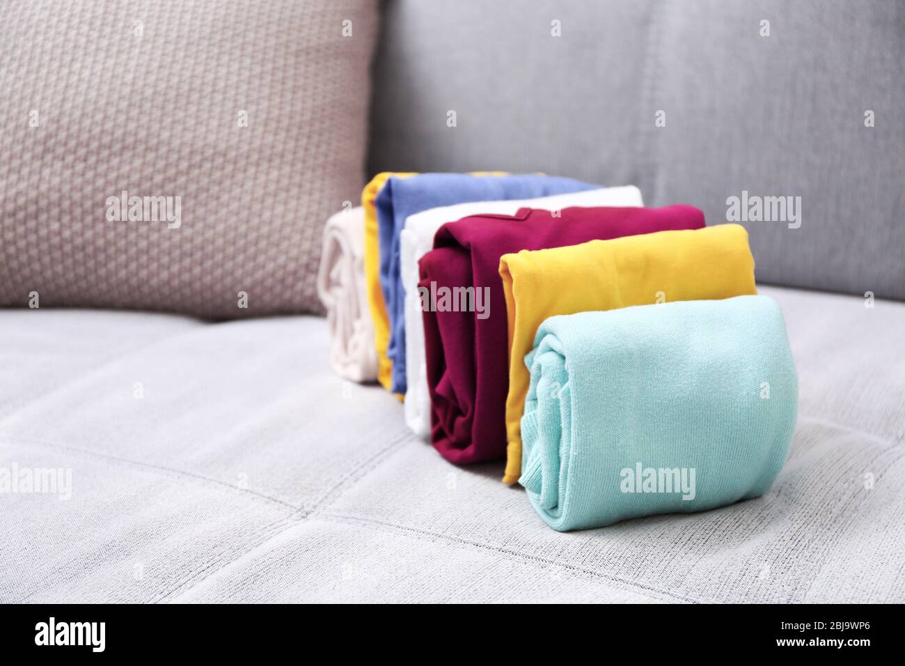 Stack of clothes on couch Stock Photo - Alamy