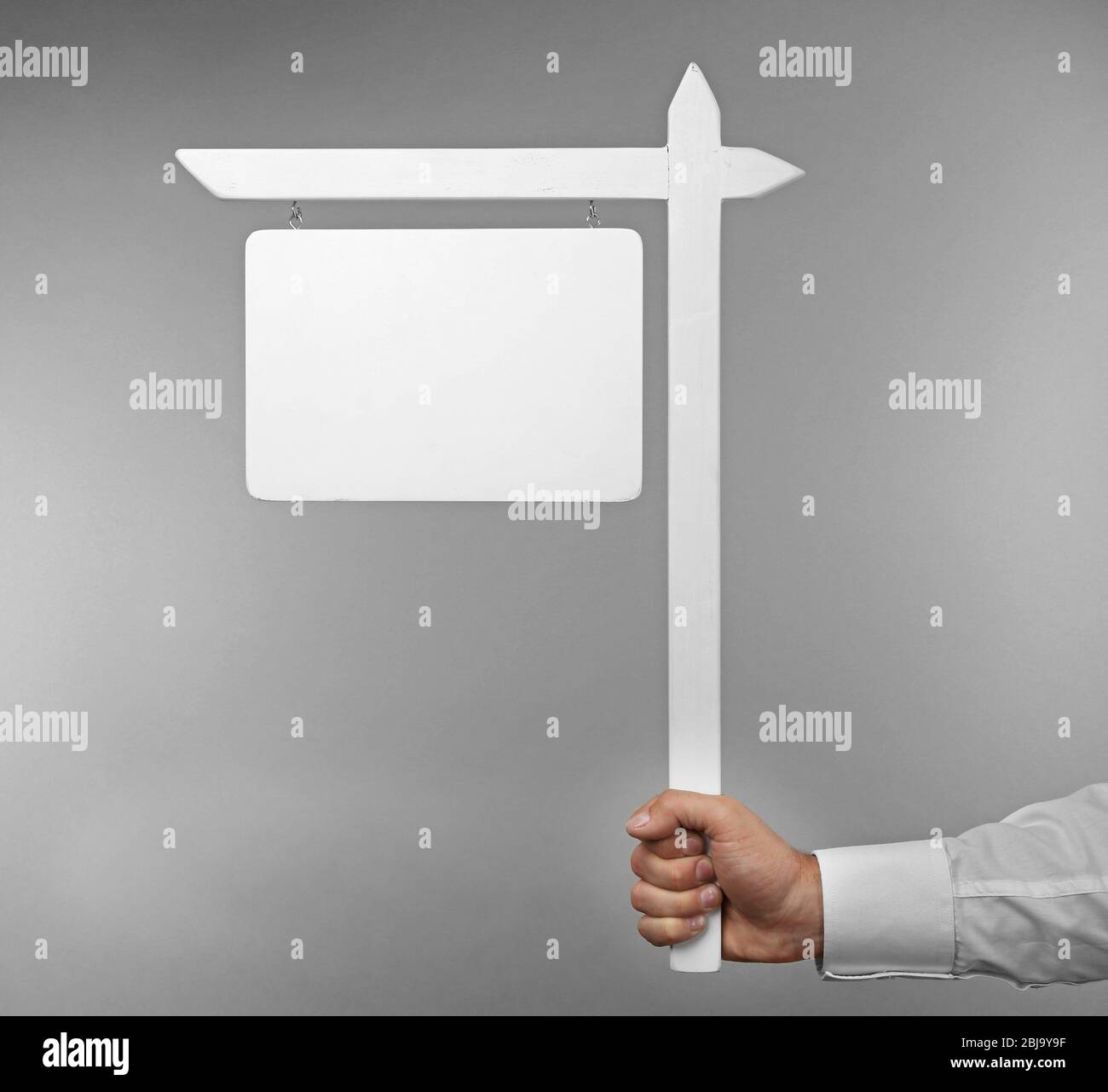 Man's hand holding white sign board on light background Stock Photo - Alamy